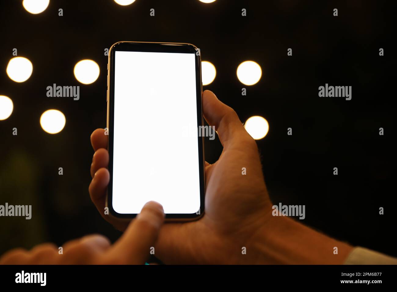 Man using modern mobile phone outdoors at night, closeup Stock Photo ...