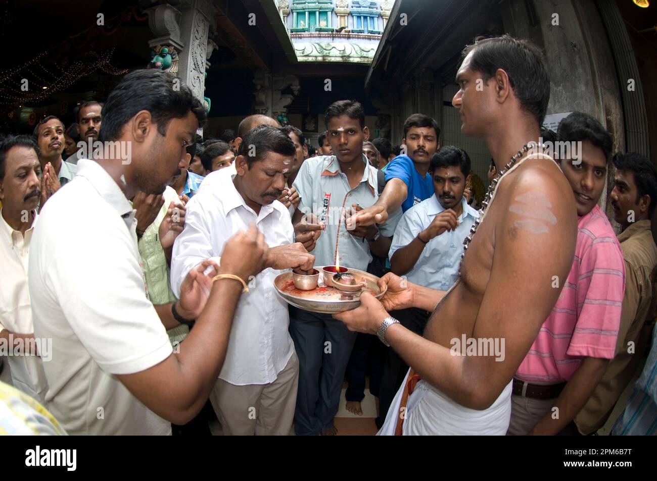 Priest passing around trays with holy flame for devotees during ...