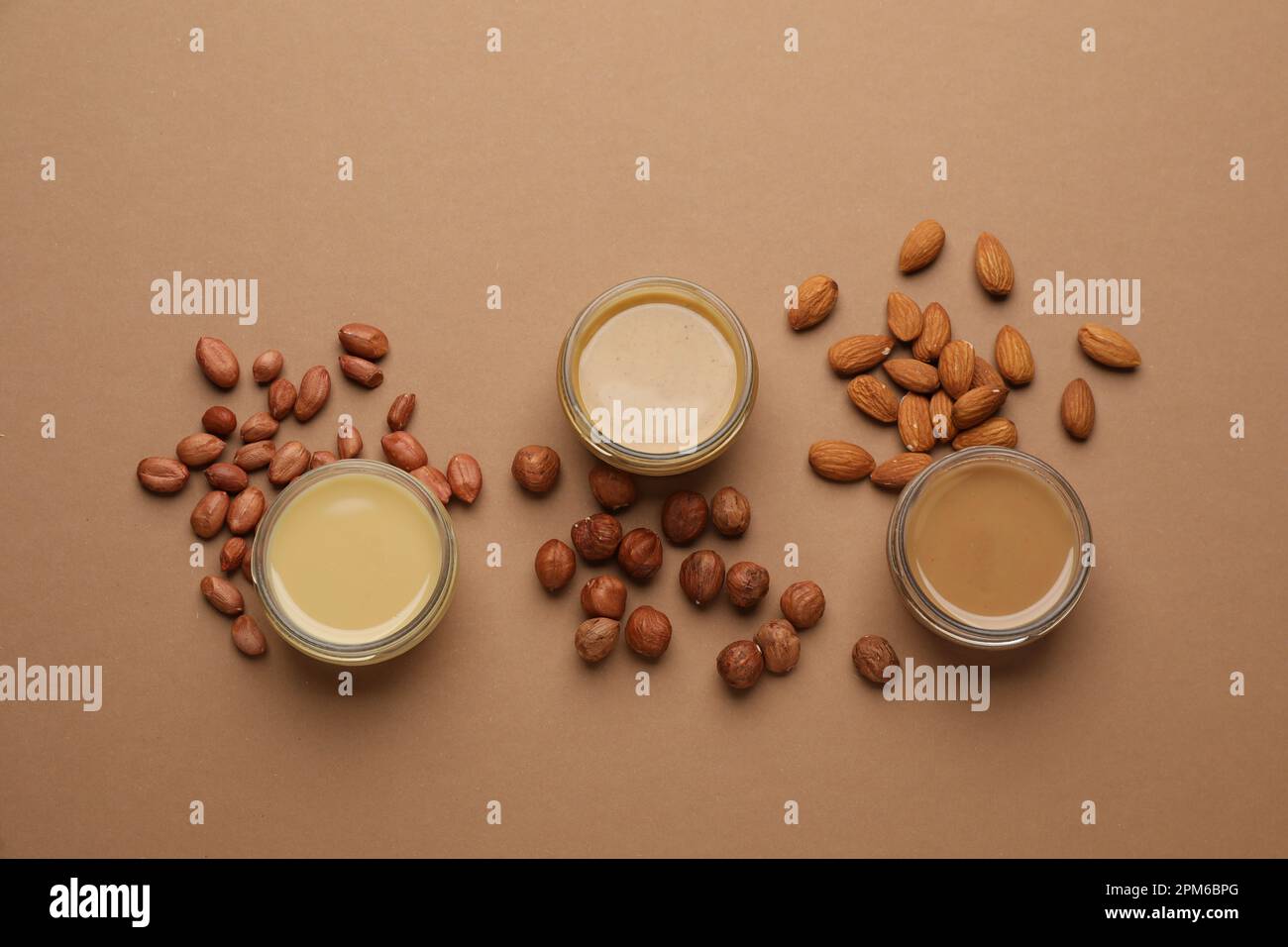 Different types of delicious nut butters and ingredients on brown ...