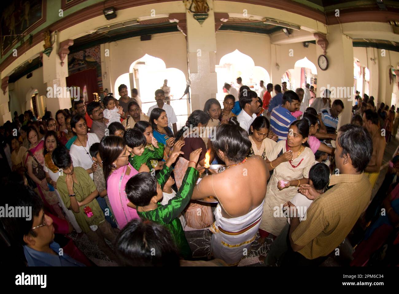 Priest passing around trays with holy flame for devotees at ceremony ...