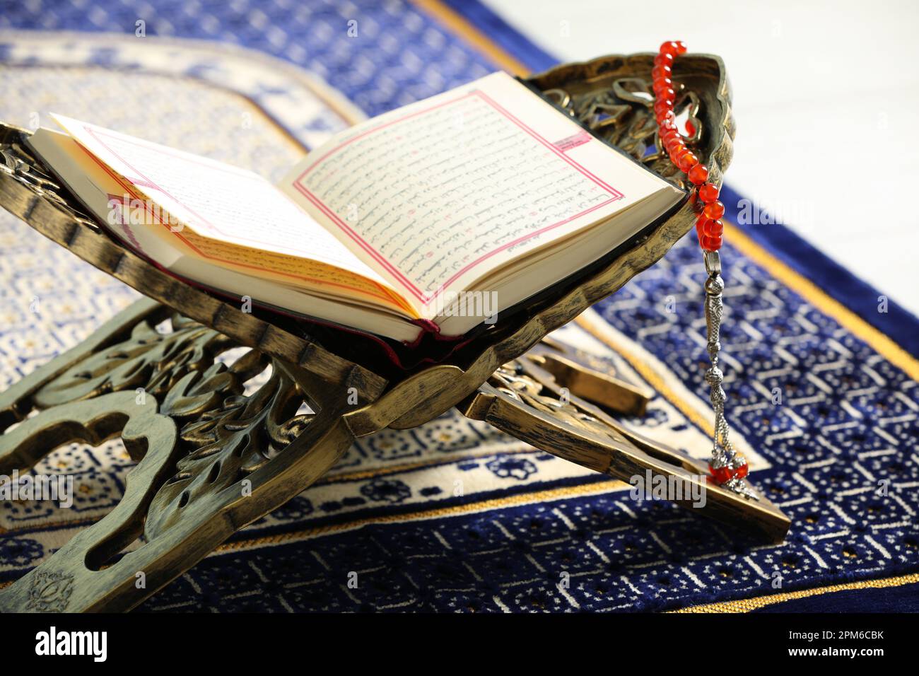 Rehal with open Quran and Misbaha on Muslim prayer rug, closeup Stock ...
