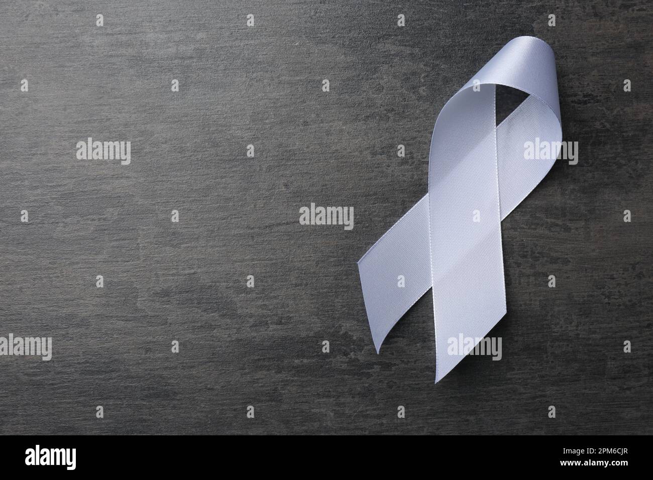 White awareness ribbon on grey table, top view. Space for text Stock ...