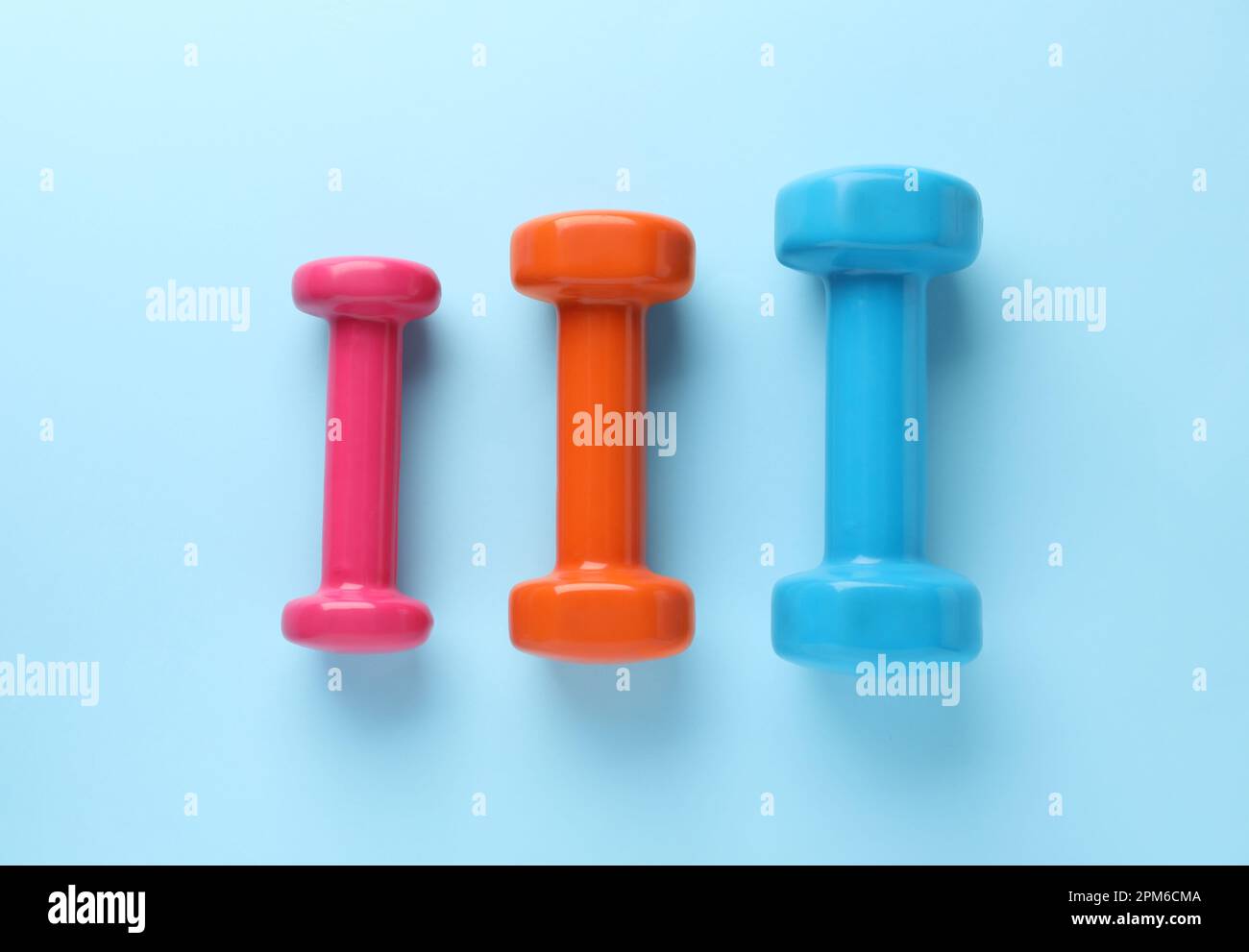 Different stylish dumbbells on light blue background, flat lay Stock ...