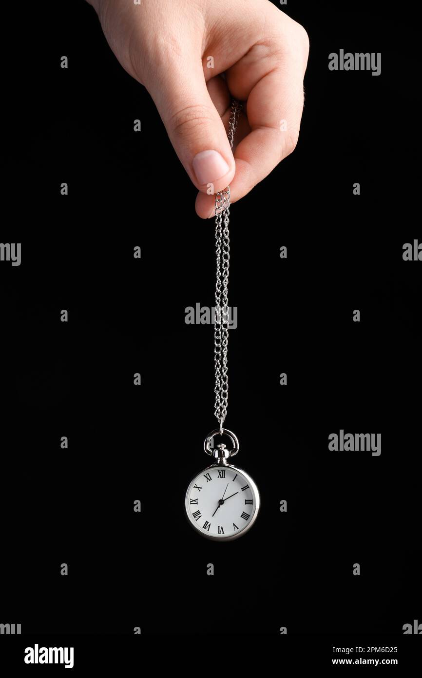 Psychotherapist with pendulum on black background, closeup ...
