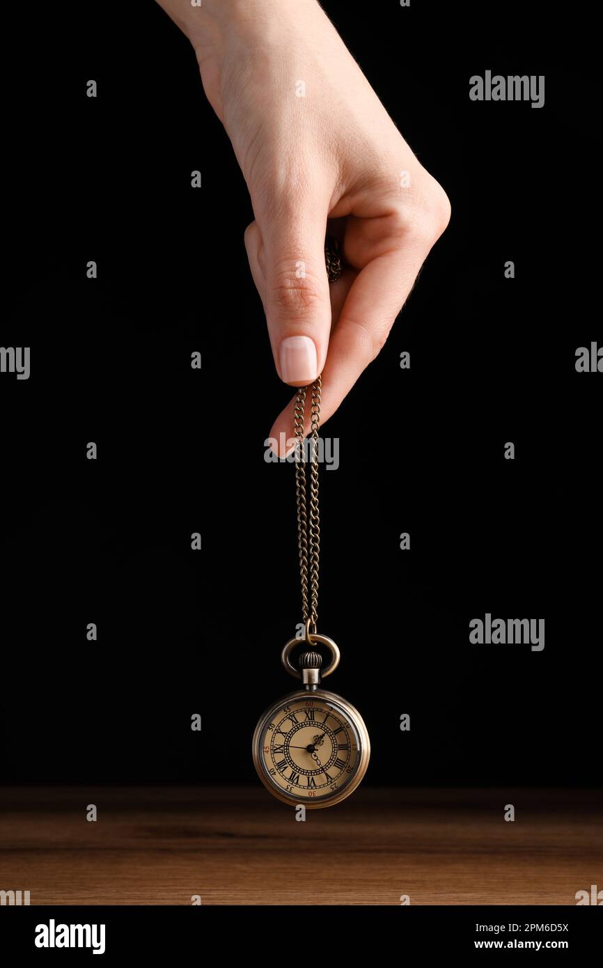 Psychotherapist with pendulum on black background, closeup ...