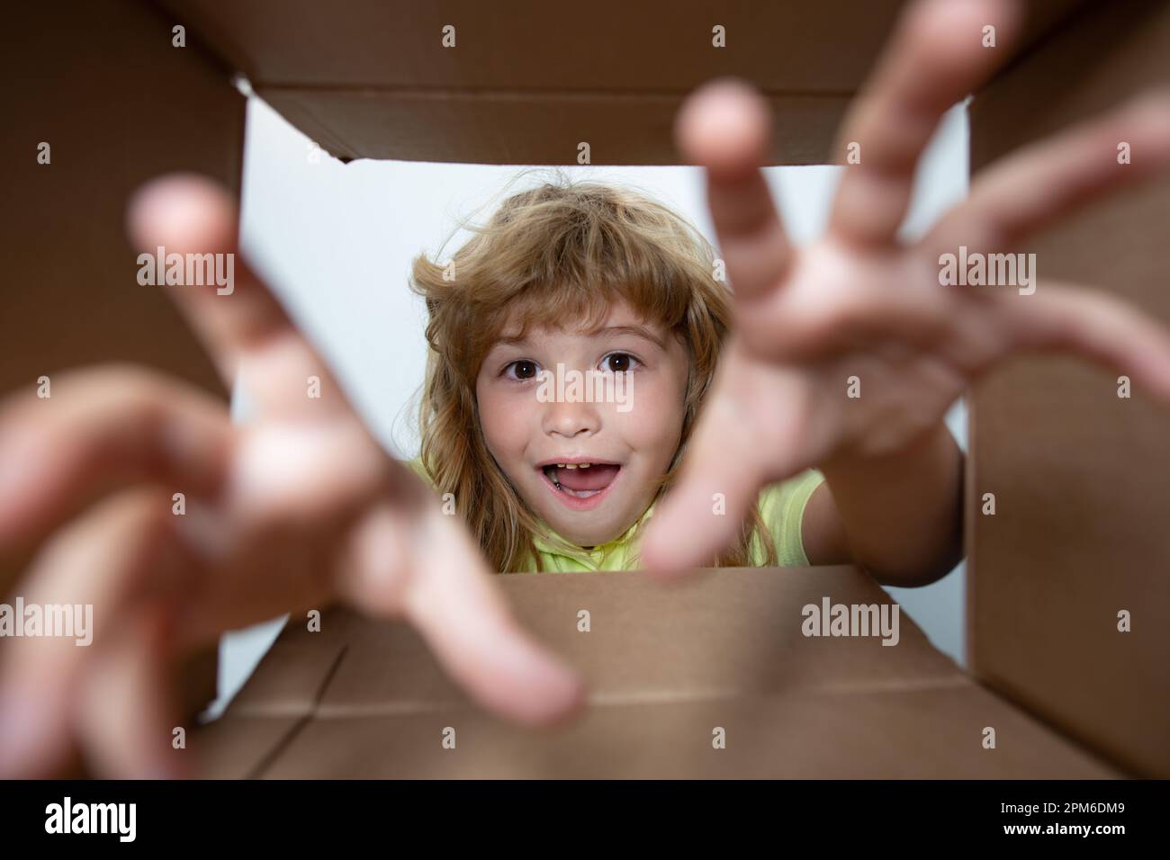 Child age 10 year opens carton box and pulling out gift from it. Small ...