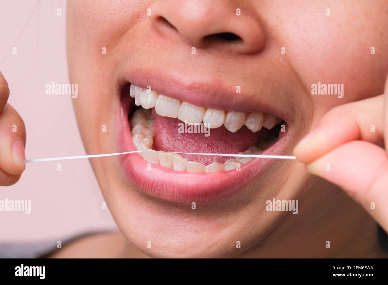 Close-up of smiling asian woman and cleaning for perfect smile. Healthy ...