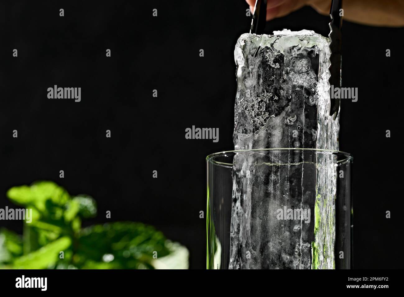 Dropping a square chimney clear ice cube into a highball glass Stock Photo - Alamy