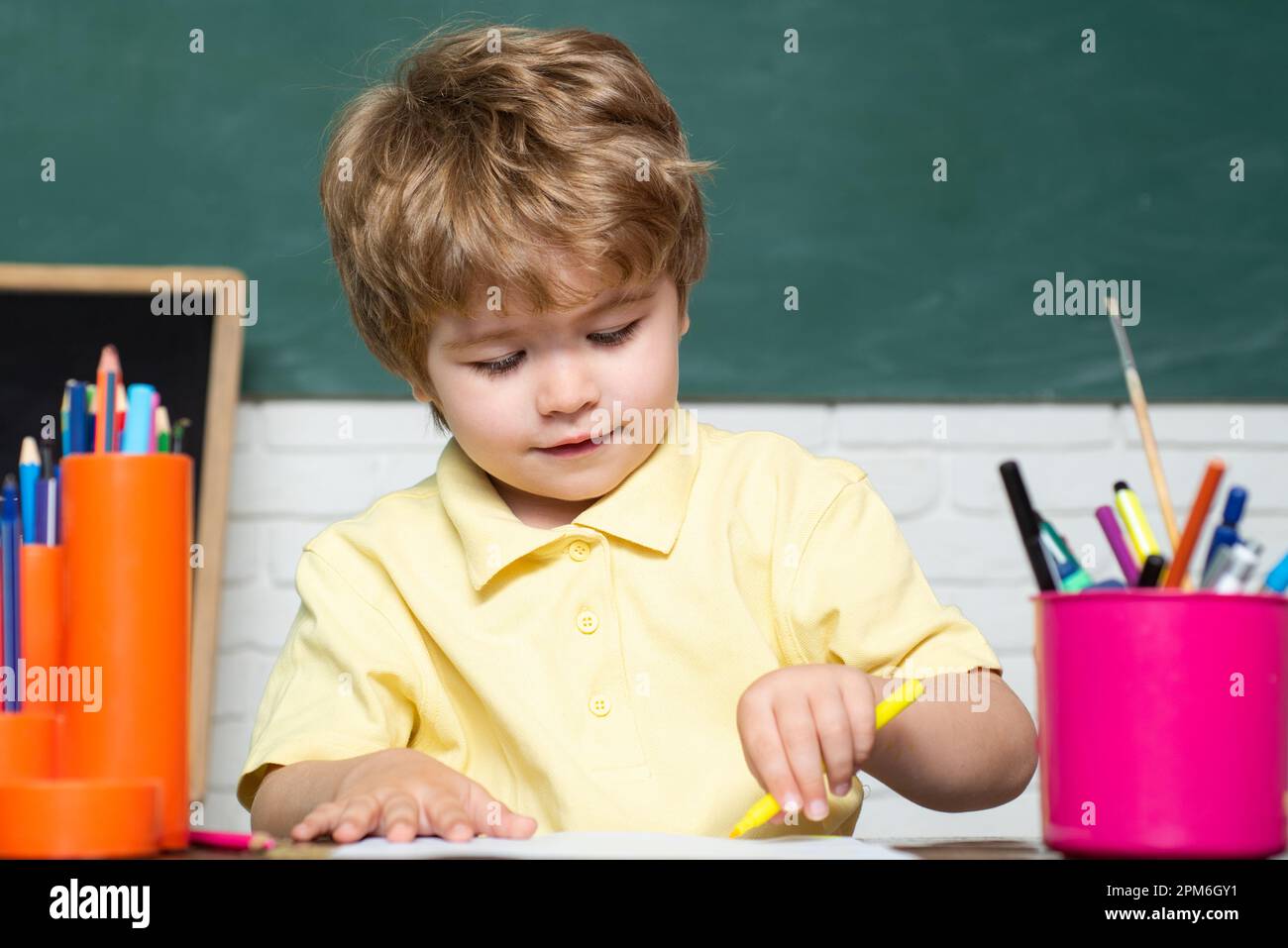 Cute little preschool kid boy study in a classroom. Cheerful smiling ...