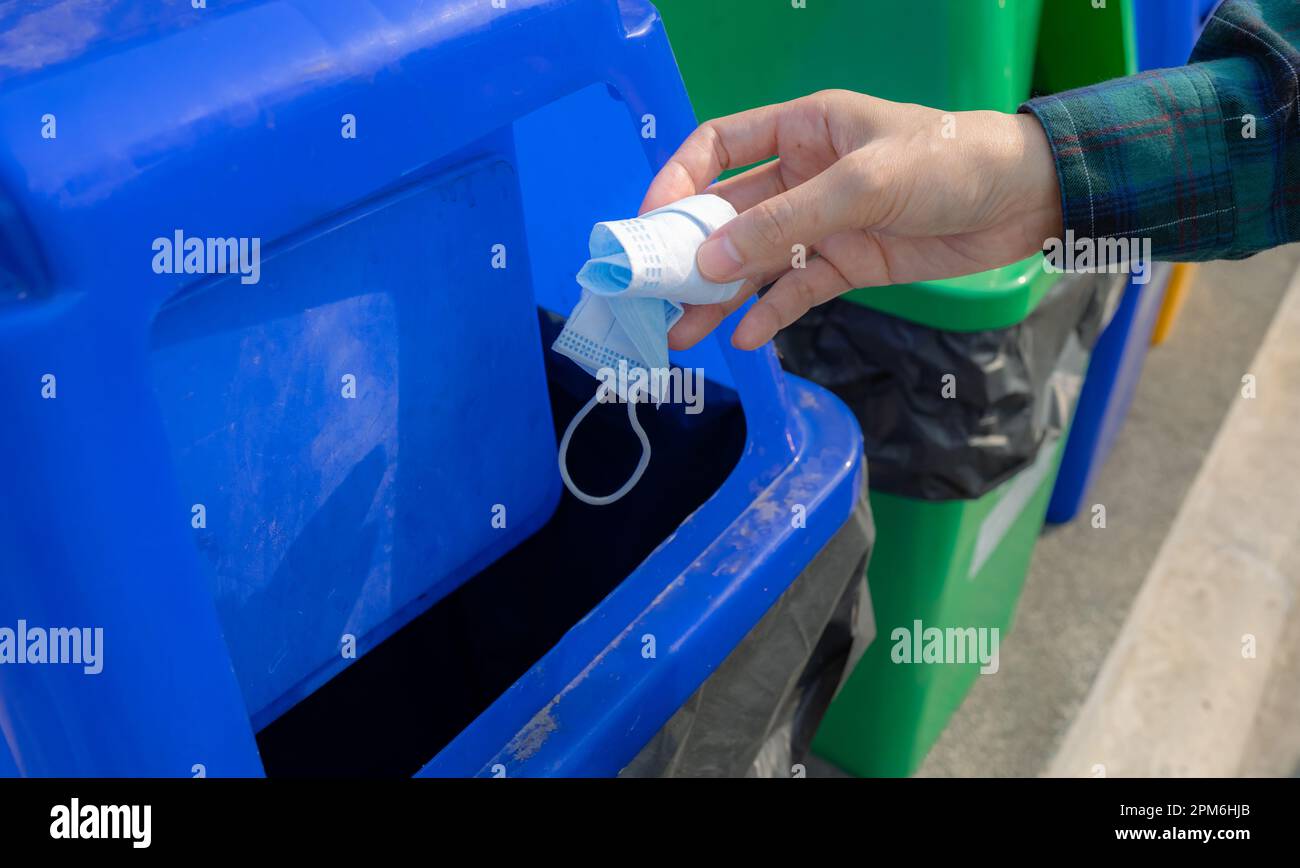 Medical waste. People hand throwing used medical protective face mask ...