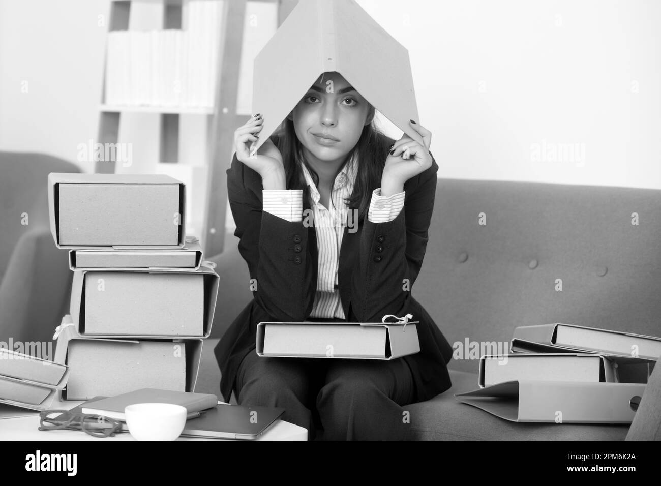 Sad busy secretary with many folders of documents, stressed overworked ...