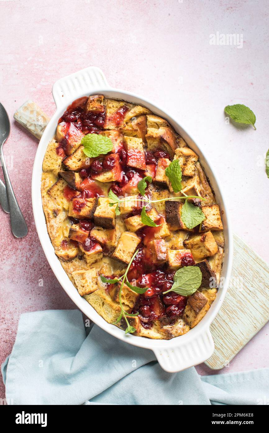Homemade bread pudding with jam on a pink concrete background ...