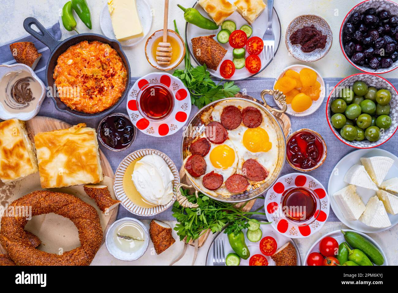 Flat-lay of Turkish breakfast with egg dishes in copper pan, pastries ...