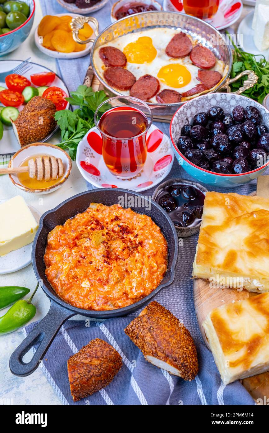 Turkish breakfast with menemen, eggs and sujuk, olives, jams, simit ...
