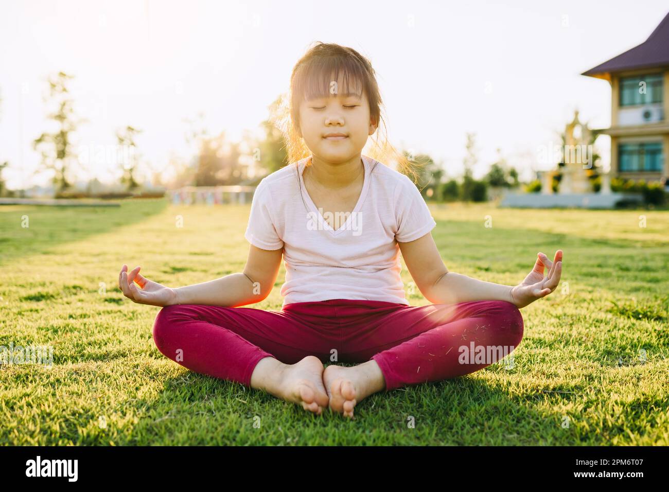 Children meditation with yoga pose on green grass field. Outdoors ...