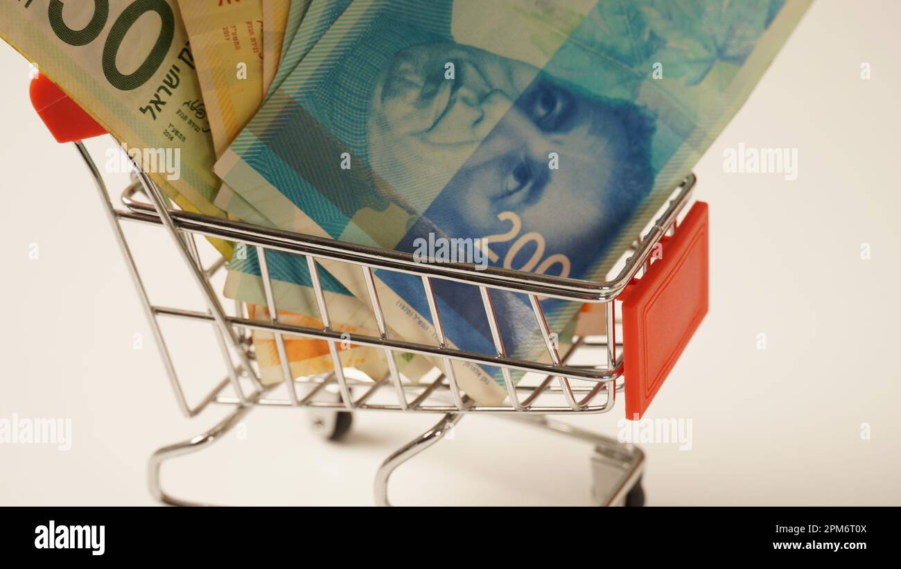 Shopping trolley with money. Israeli Shekel cash banknotes Stock Photo ...