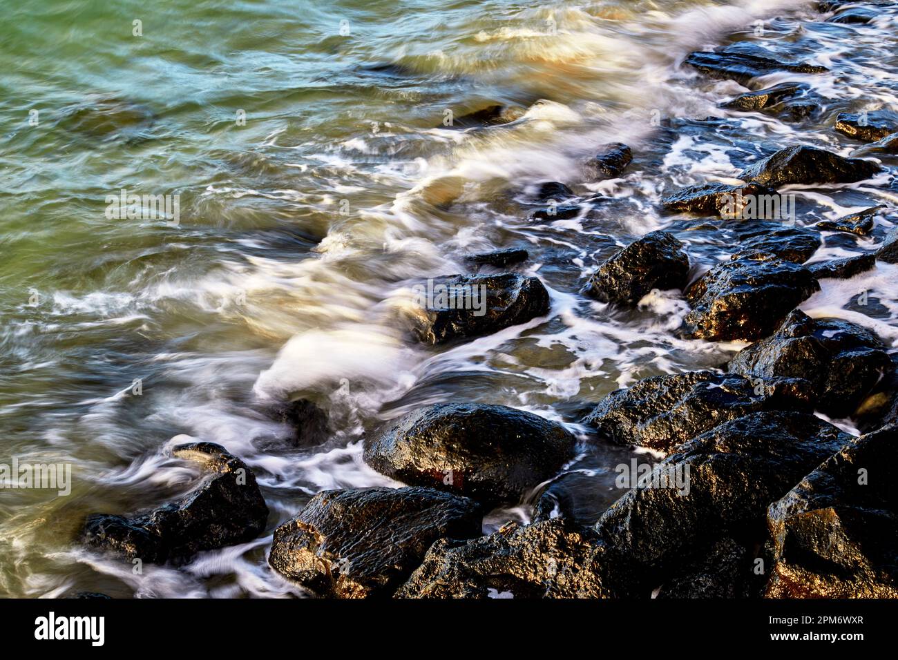 Waves splashing onto shoreline Rocks Stock Photo - Alamy