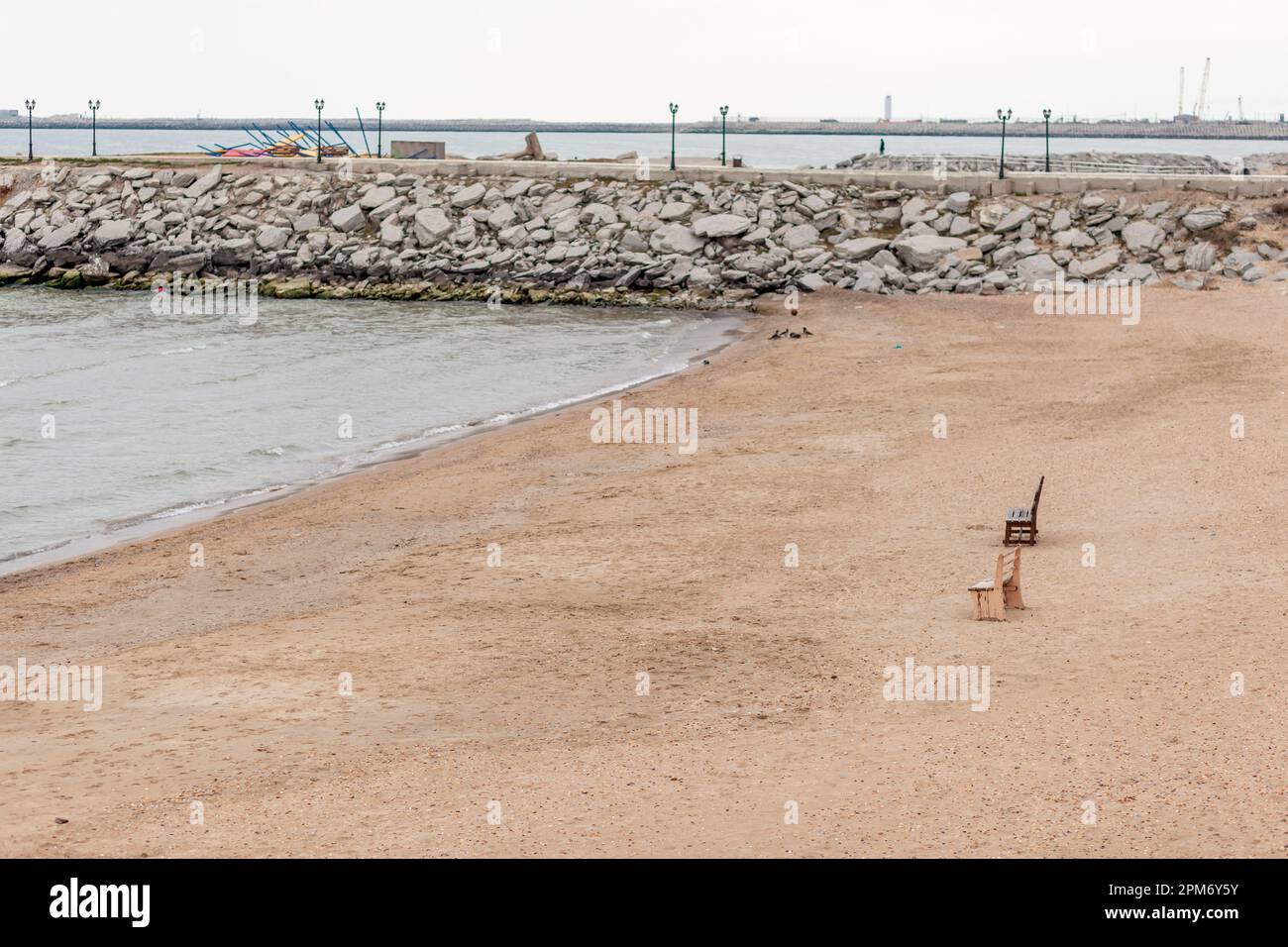 Two wooden benches stand on the beach with sand Stock Photo - Alamy
