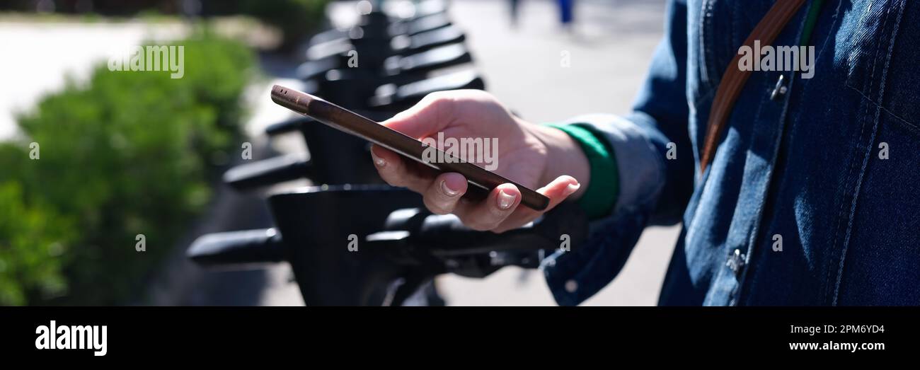 Female holding modern smartphone and paying rent Stock Photo - Alamy