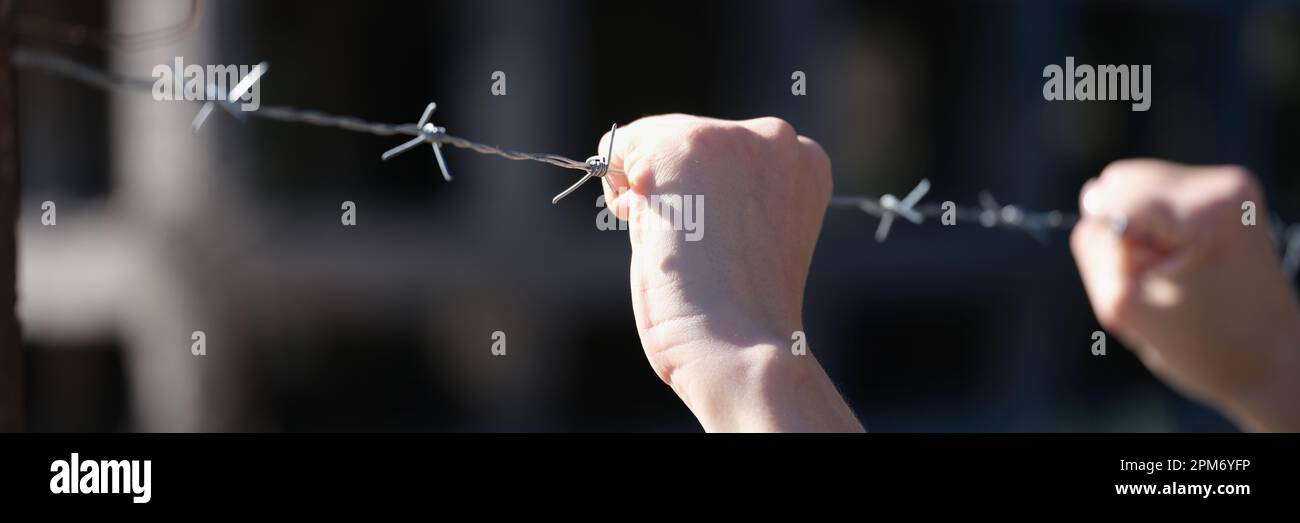 Woman hands holding metal security barbedwire fence Stock Photo - Alamy