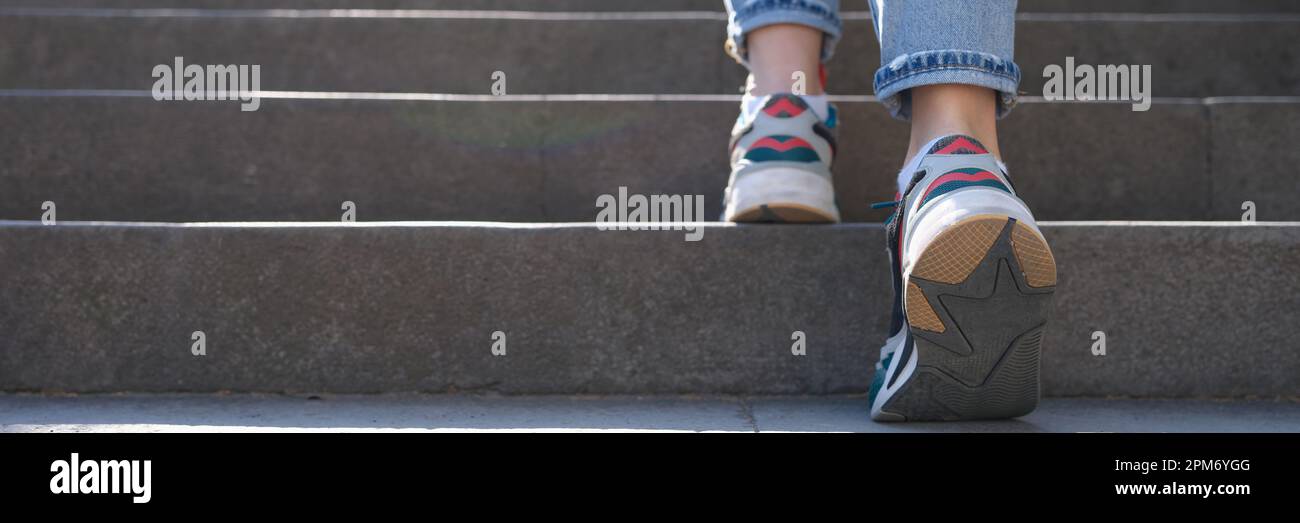 Female in jeans and sneakers going up steep stairs Stock Photo - Alamy