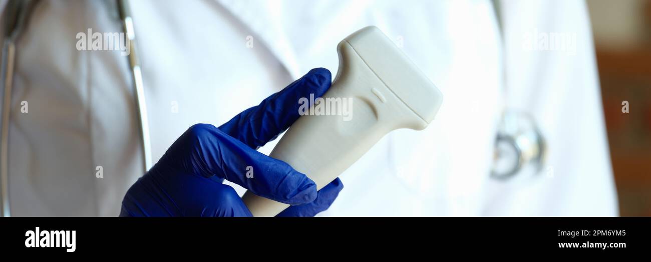 Practitioner in medical gown holding ultrasound probe in hand Stock ...