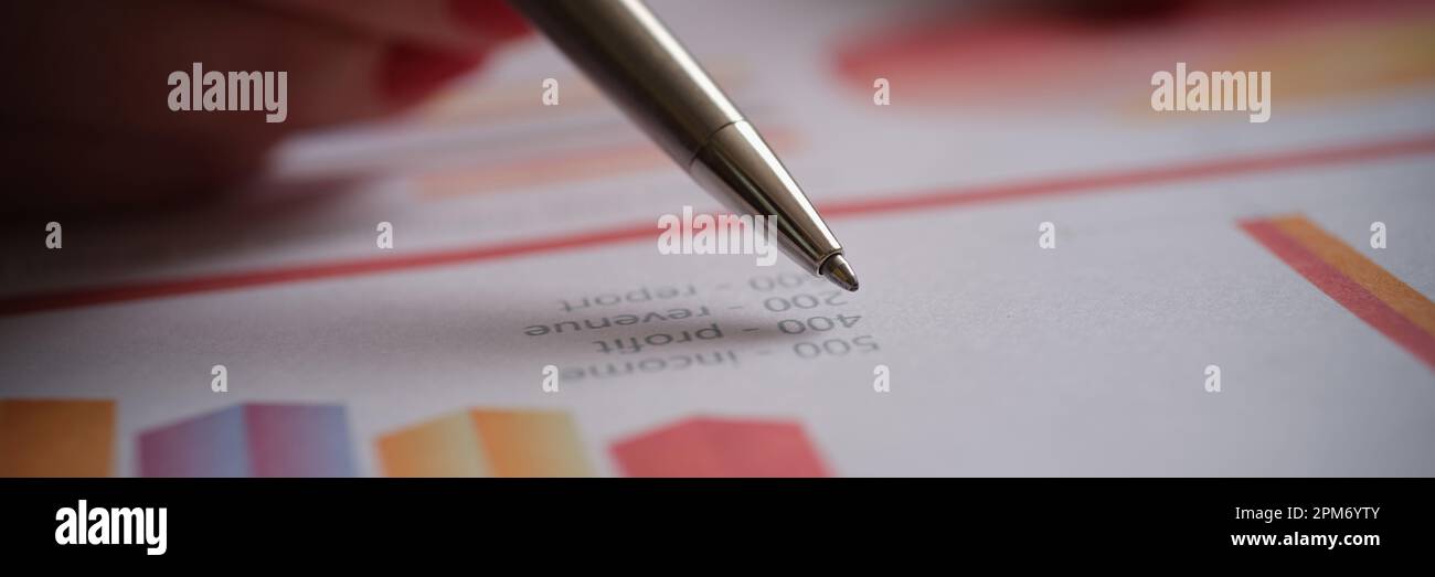 Woman hand pointing with pen on report with colourful diagrams Stock ...