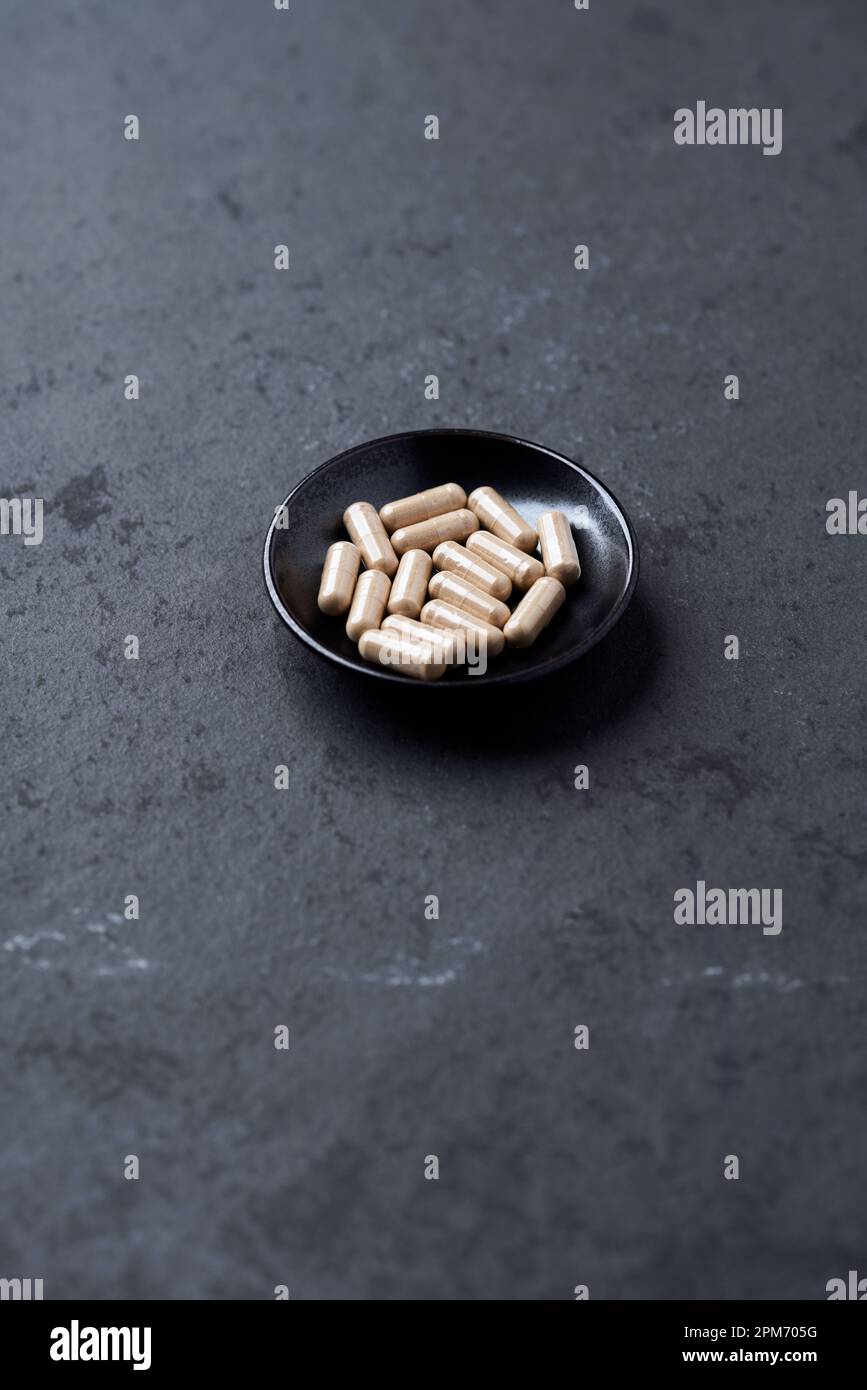 Ashwagandha (Withania somnifera) capsules. Dark stone background. Soft ...