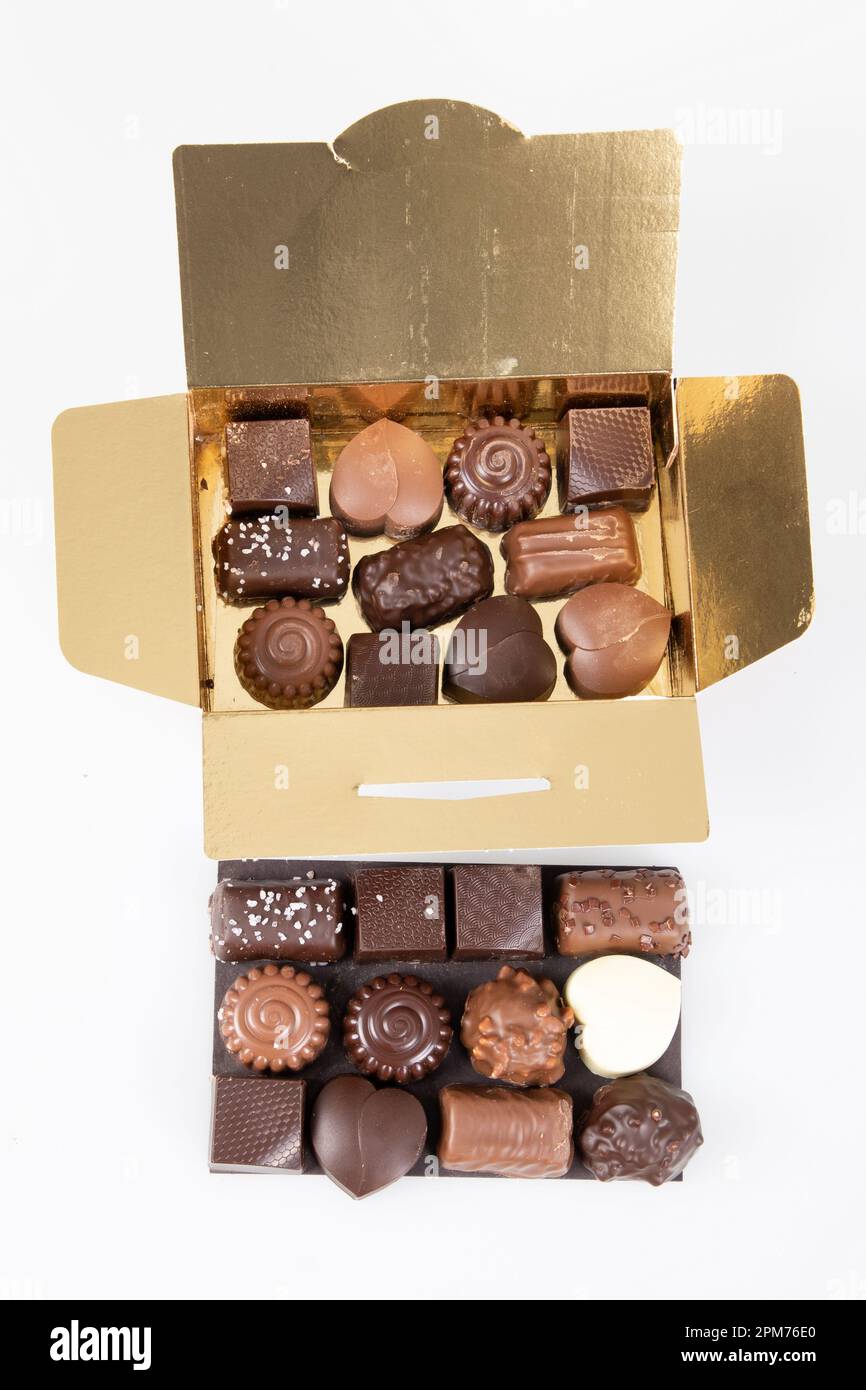 Assortment of fine chocolates candies in small golden open gift gold ...