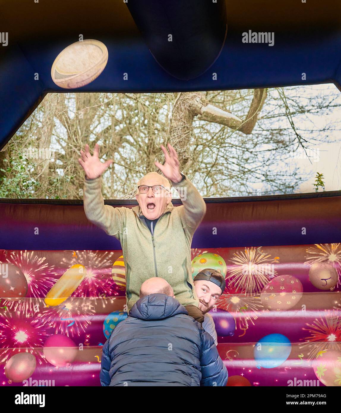 An octogenarian man, lifted up by a son and a grandson, practises his ...