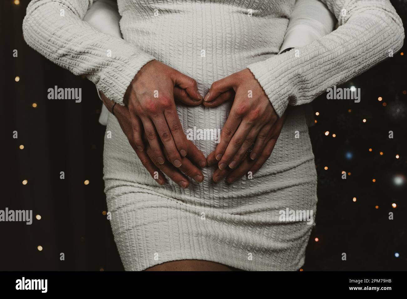 A loving couple embracing, the pregnant woman tenderly placing her ...