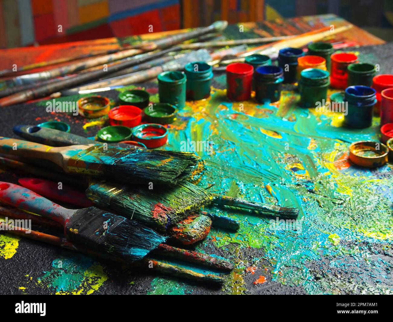 Acrylic colors, palette and brushes in the art studio. Colorful, multi ...