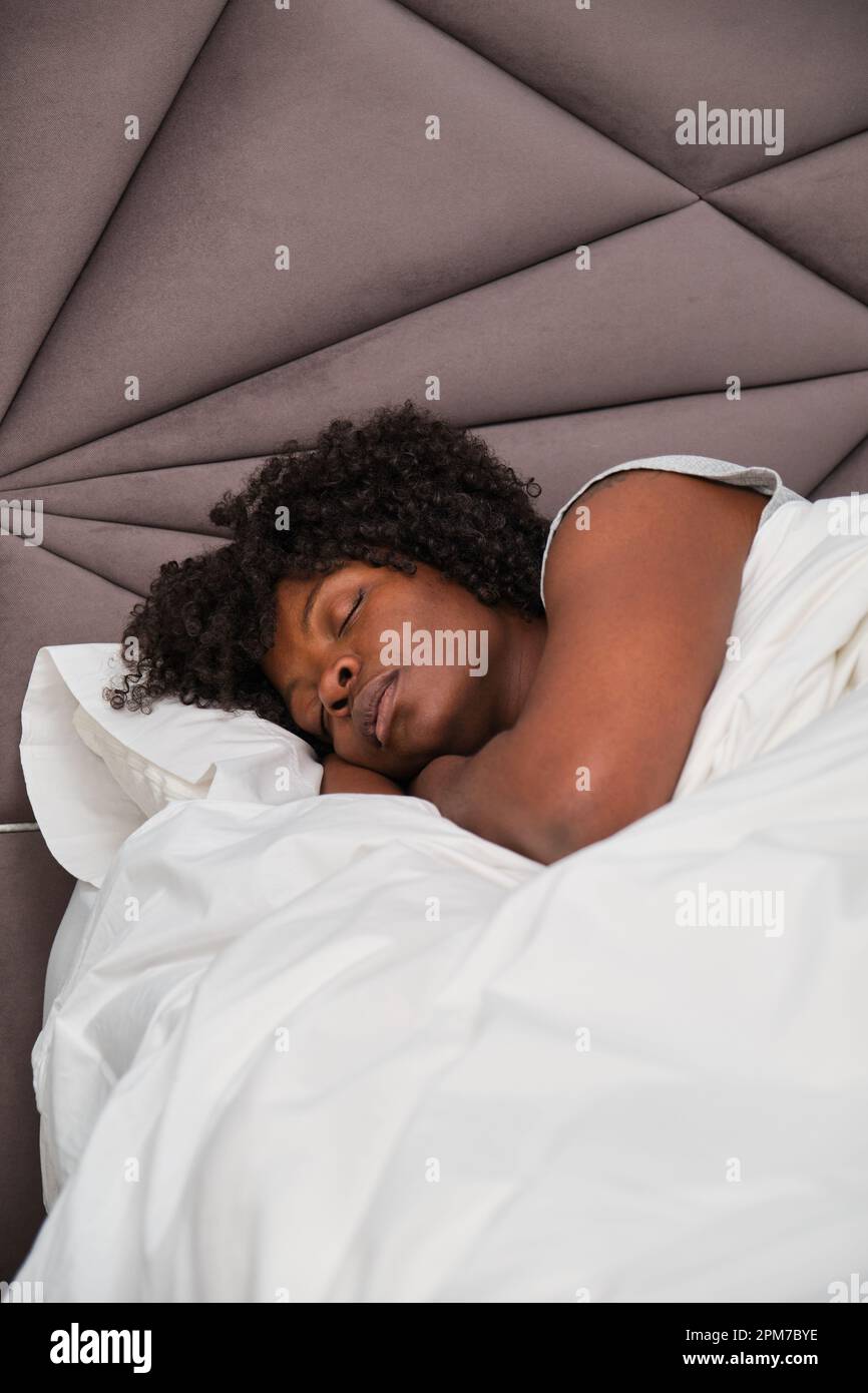 African young woman asleep on white sheets in bed Stock Photo - Alamy