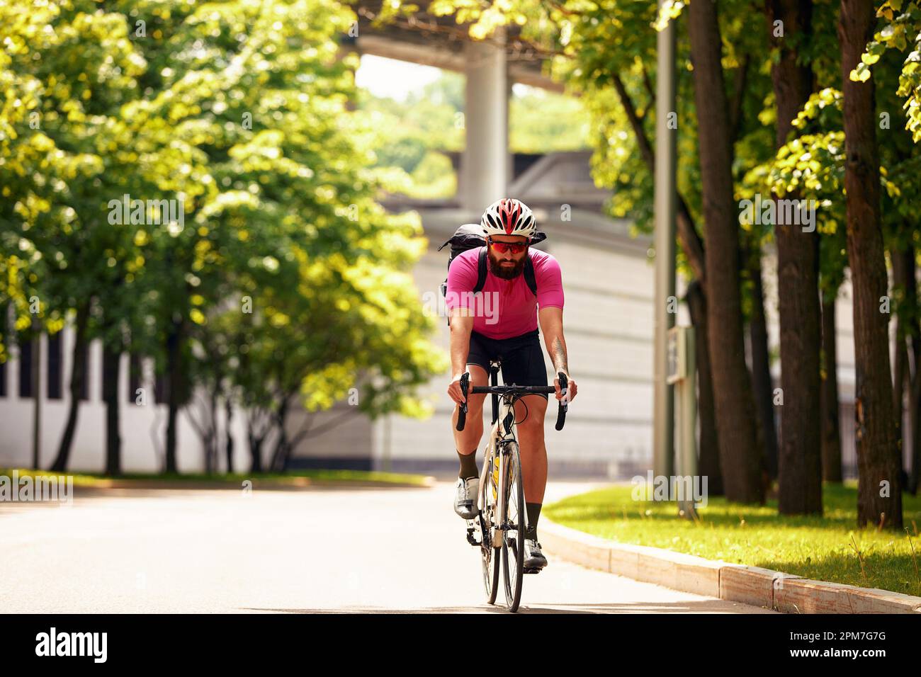 Strong Male cyclist in sportswear, glasses and protective helmet ...