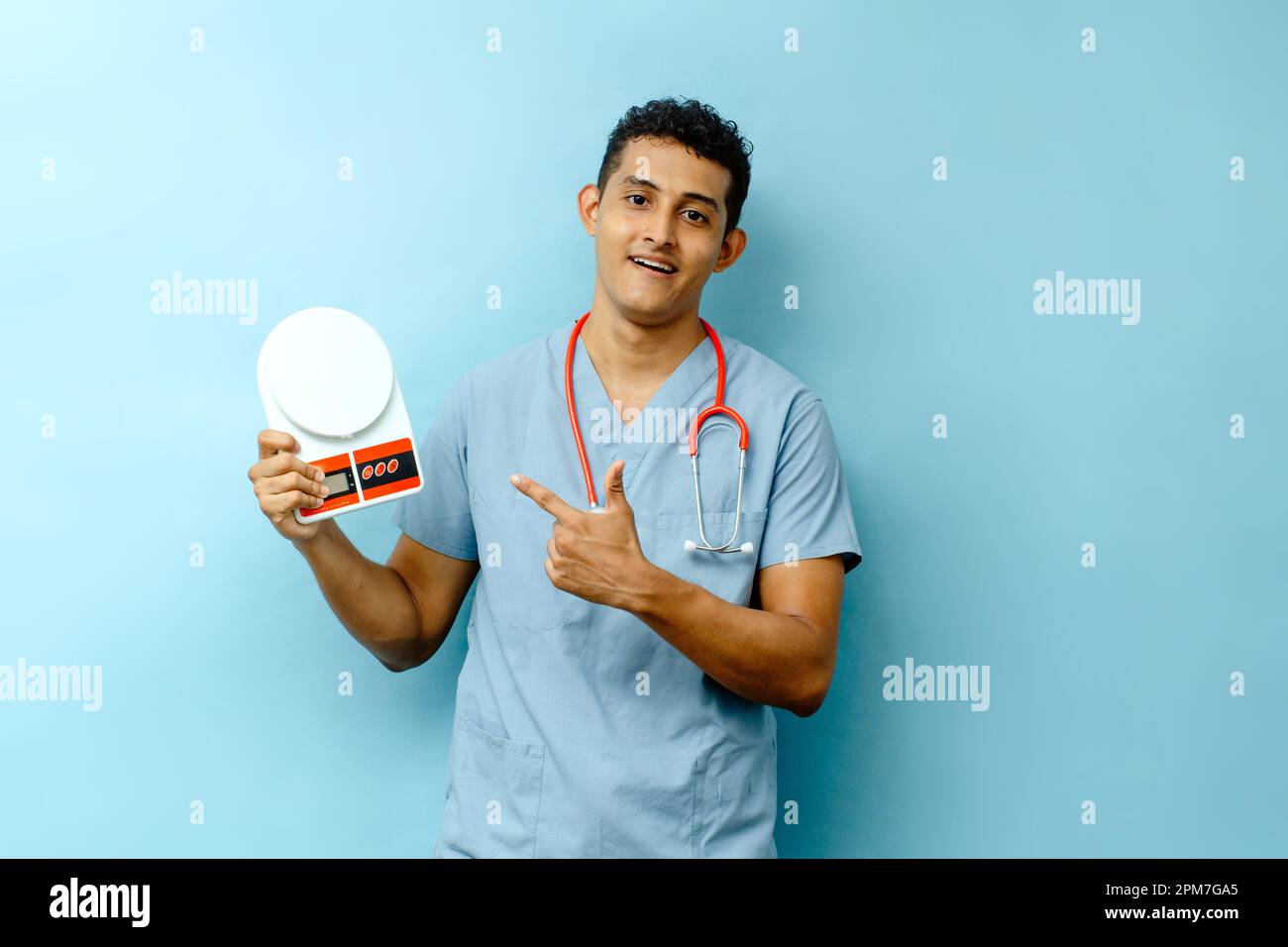 An experienced doctor stands with an electronic scale in hand on the ...