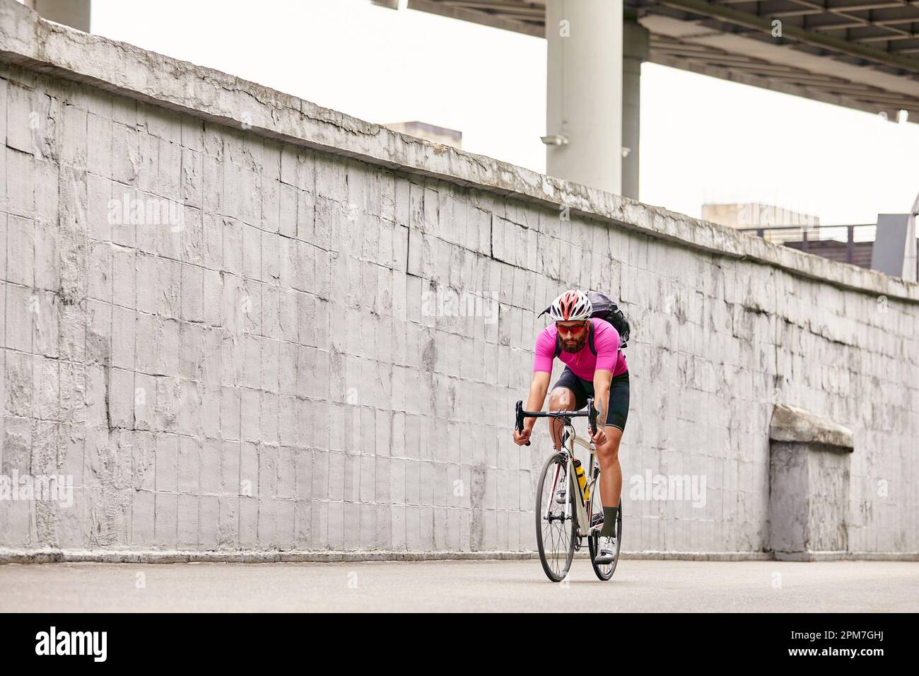 A young cyclist against the backdrop of urban architecture in bright ...