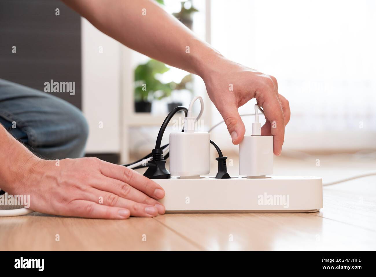 Hand holding electric plug, Multiple socket with connected plugs ...