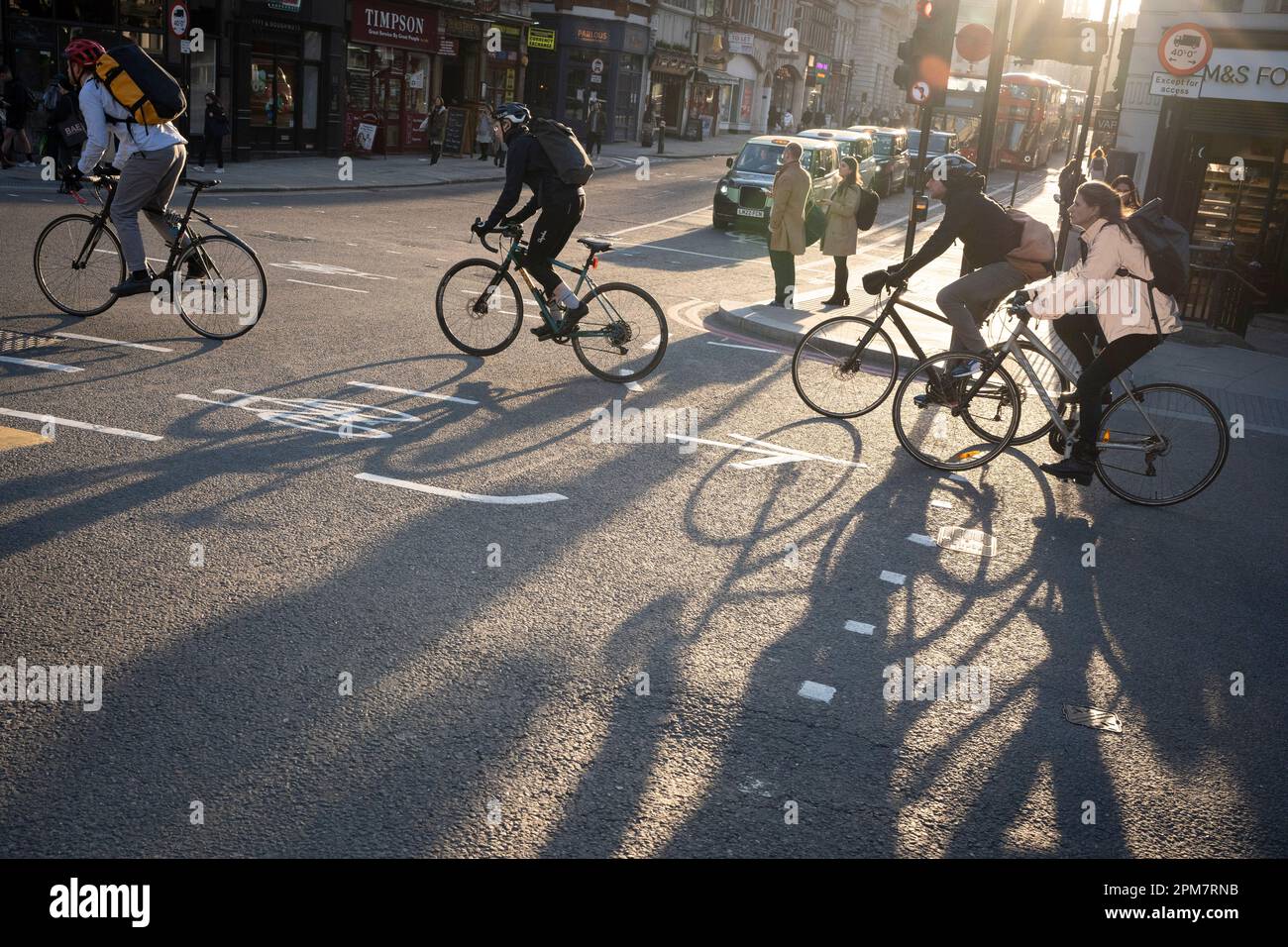 Cyclists and commuters make their ways home in evening sunshine at the ...
