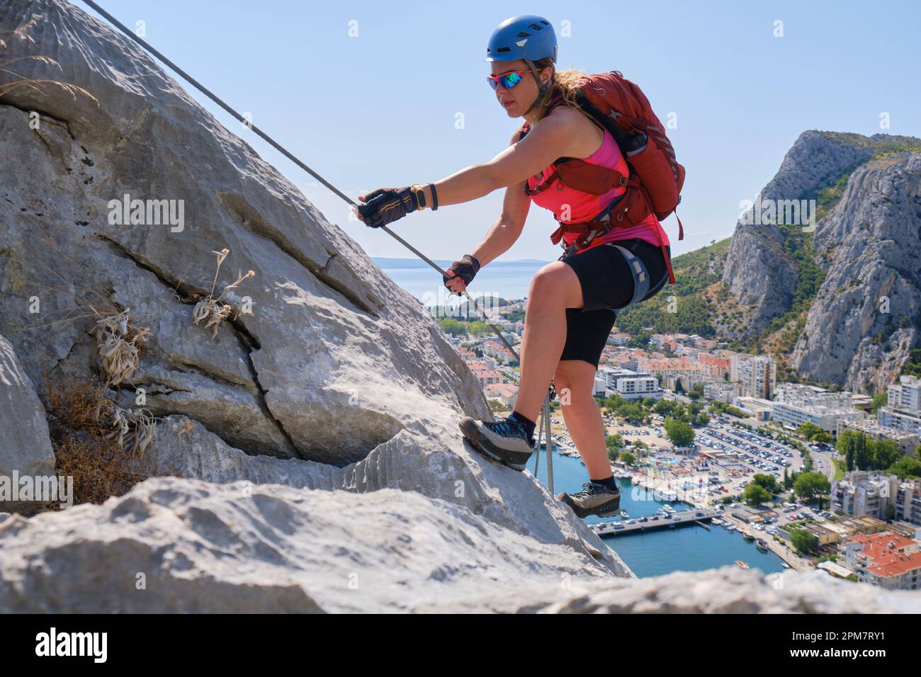 Woman climbs via ferrata Fortica, above Omis city, Croatia, in the ...
