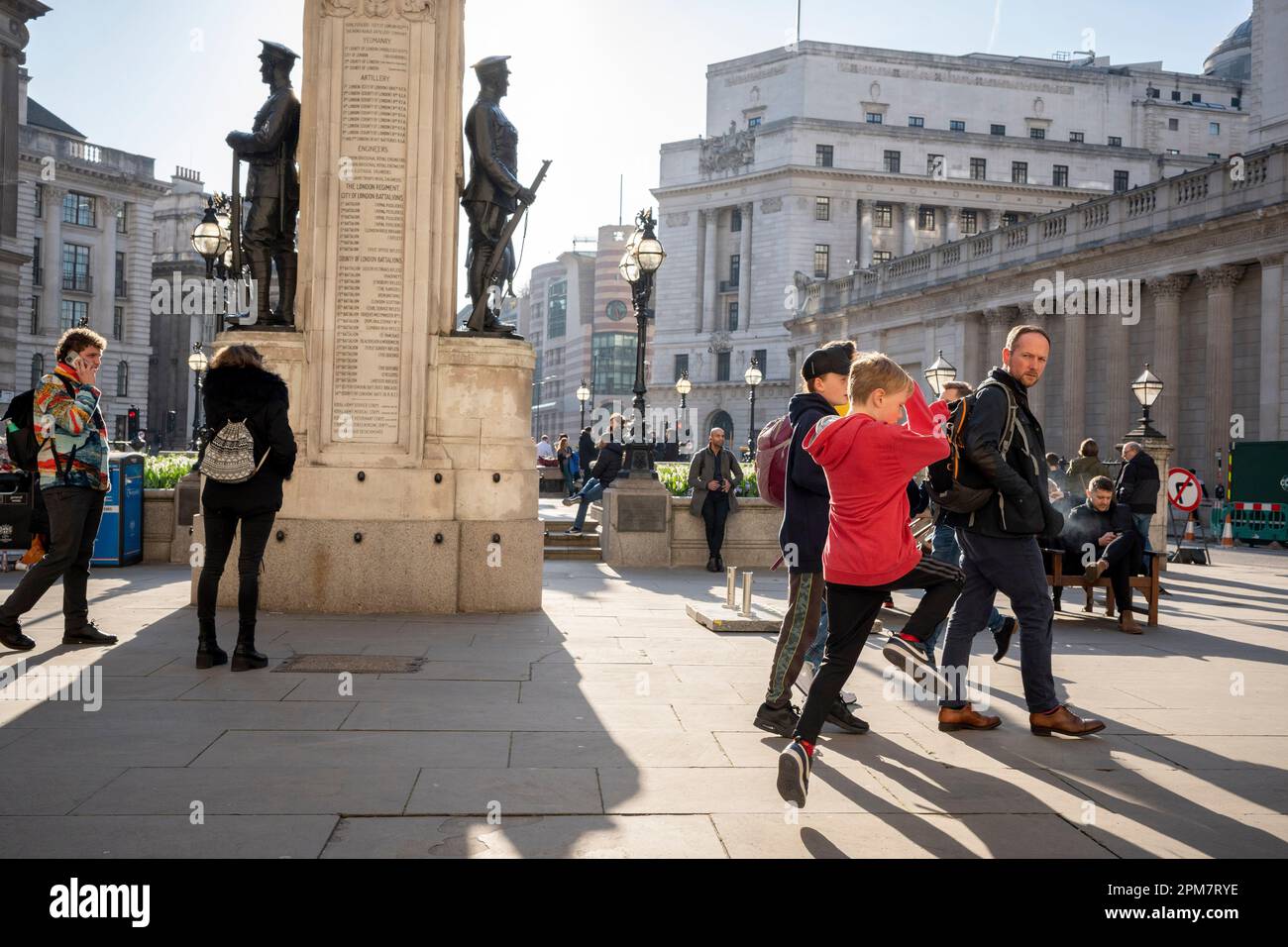 A boy leaps in the air as workers and visitors to London pass-by the ...
