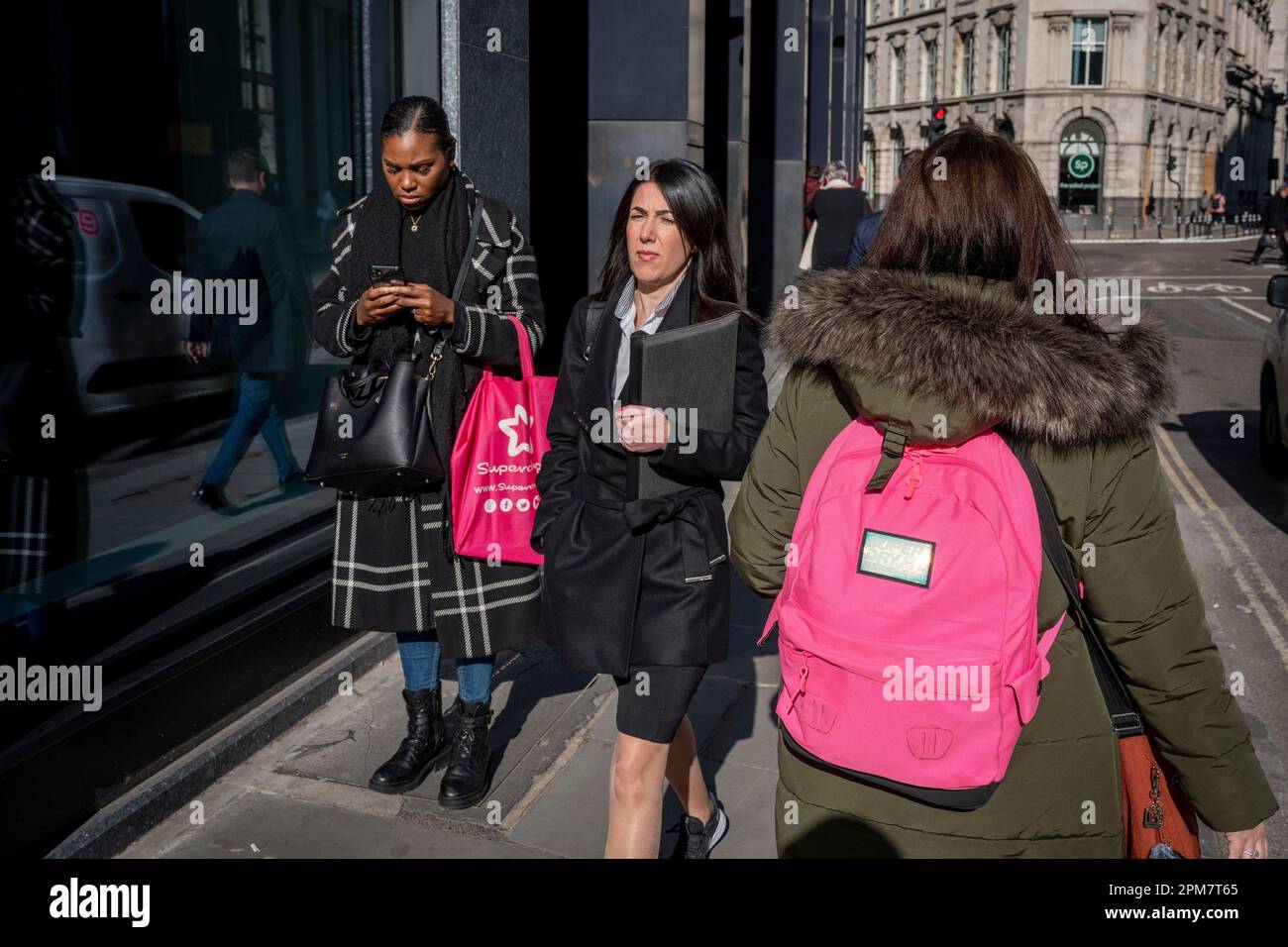 Three woman pass each other in the City of London, aka the Square Mile ...