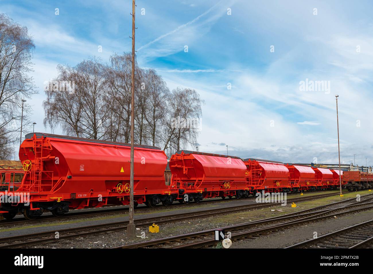 Bright red railway tanks stand on the sidings. Blue sky with light ...