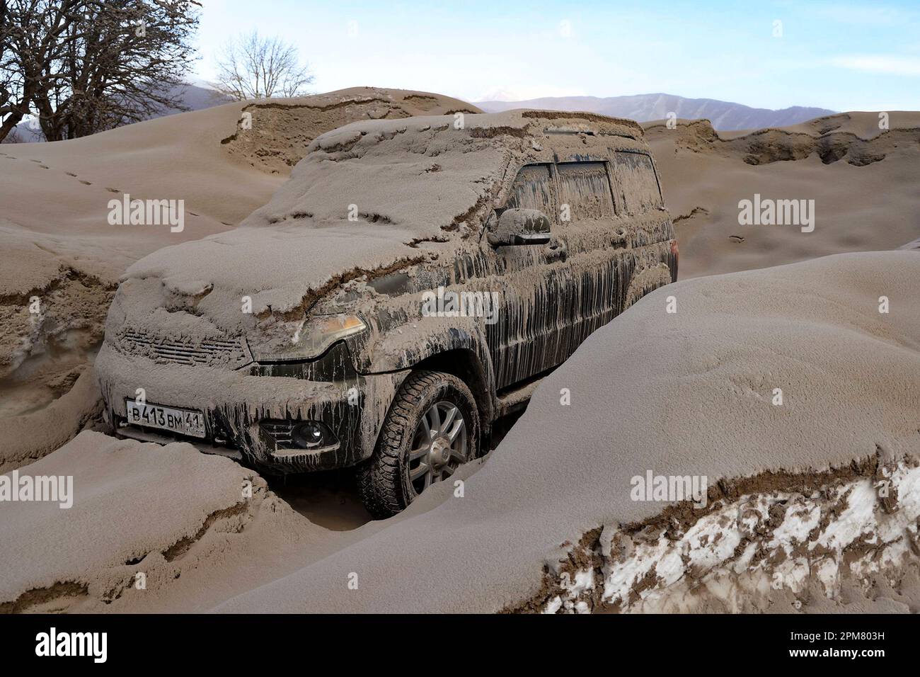 Volcanic ash covers the ground and a car after the Shiveluch volcano ...