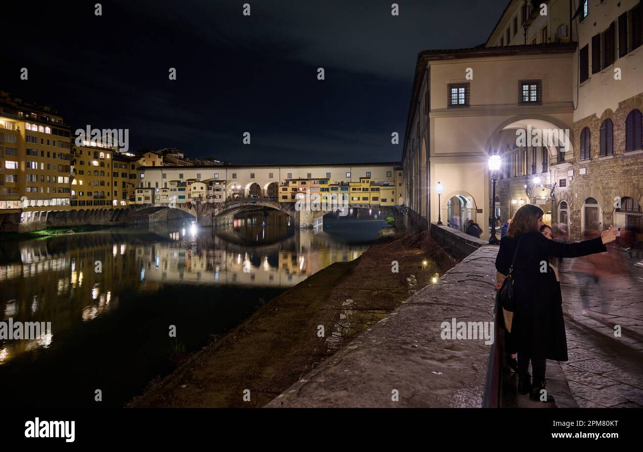 night shot of illuminated medieval brigde Ponte Vecchio over Arno river ...