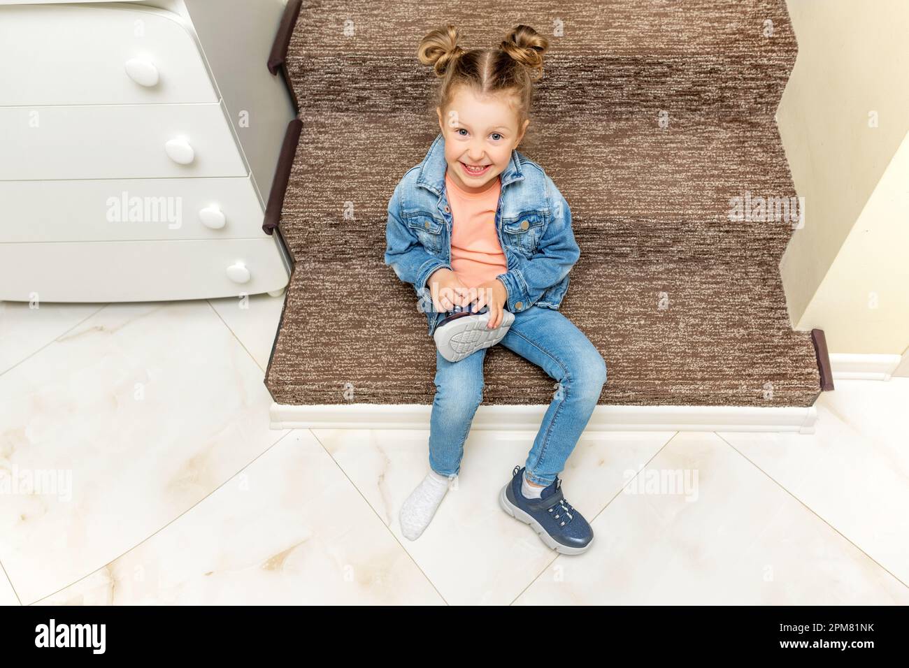 The child has learned how to put on shoes on his own Stock Photo - Alamy