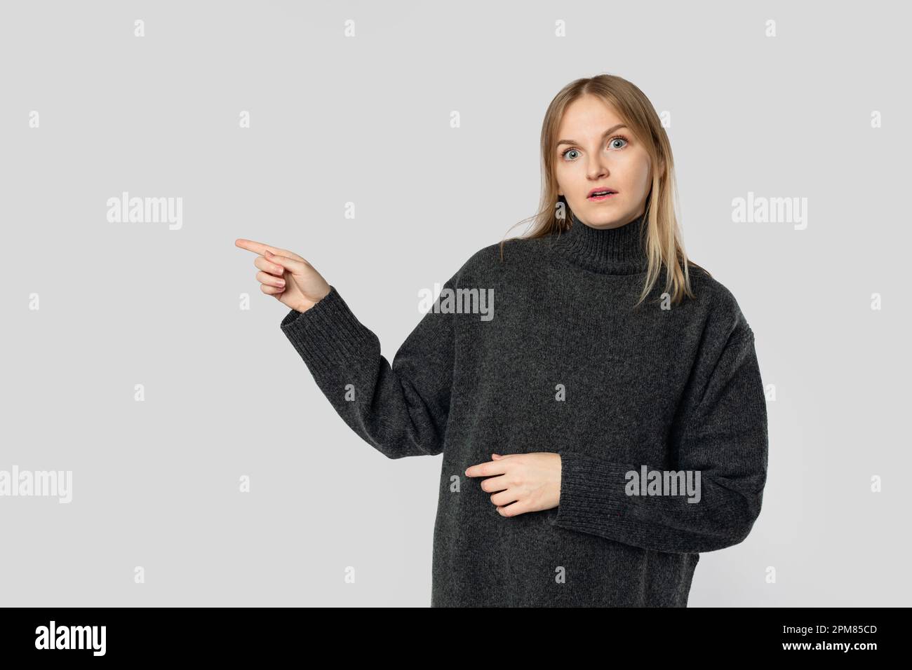 Surprised woman showing point at blank empty copy space isolated on ...