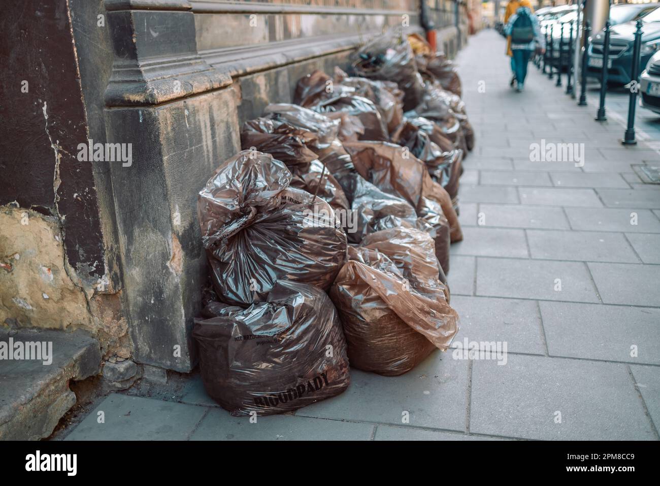 Pile of black garbage on the footpath at side road in big city ...
