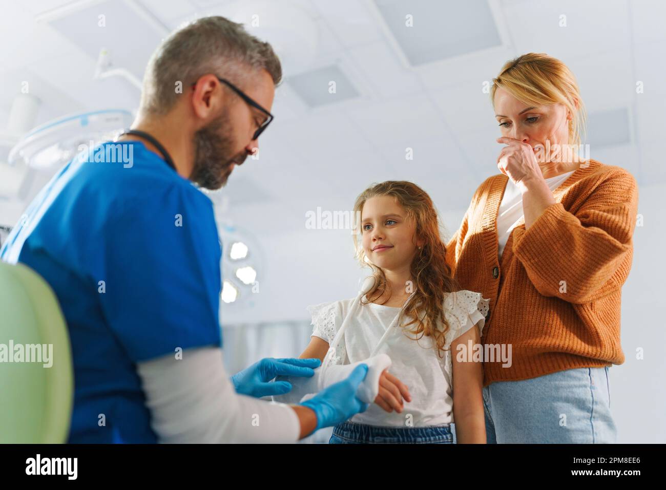 Mature doctor giving gypsum to little girl Stock Photo - Alamy