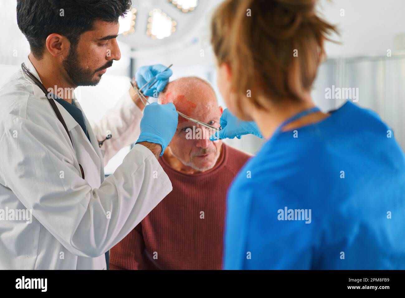 Young doctor and nurse treating injury of senior man Stock Photo - Alamy