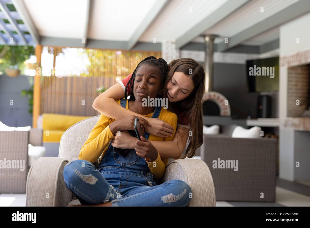 Sad diverse teenager girls friends sitting in armchair, embracing and ...